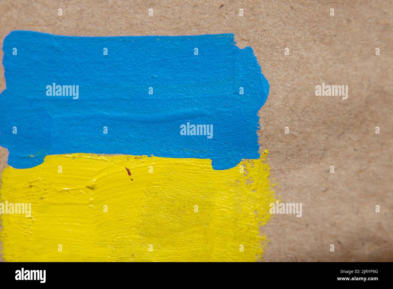 The flag of Ukraine is painted with paints on brown paper, wallpaper ...