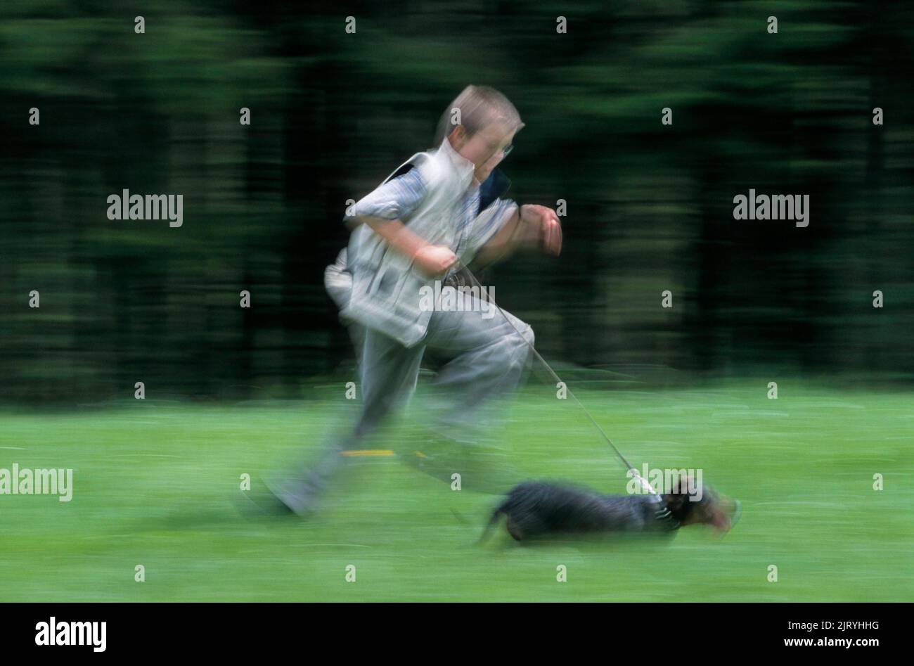 Boy running fast with dog, sharpness of movement Stock Photo - Alamy