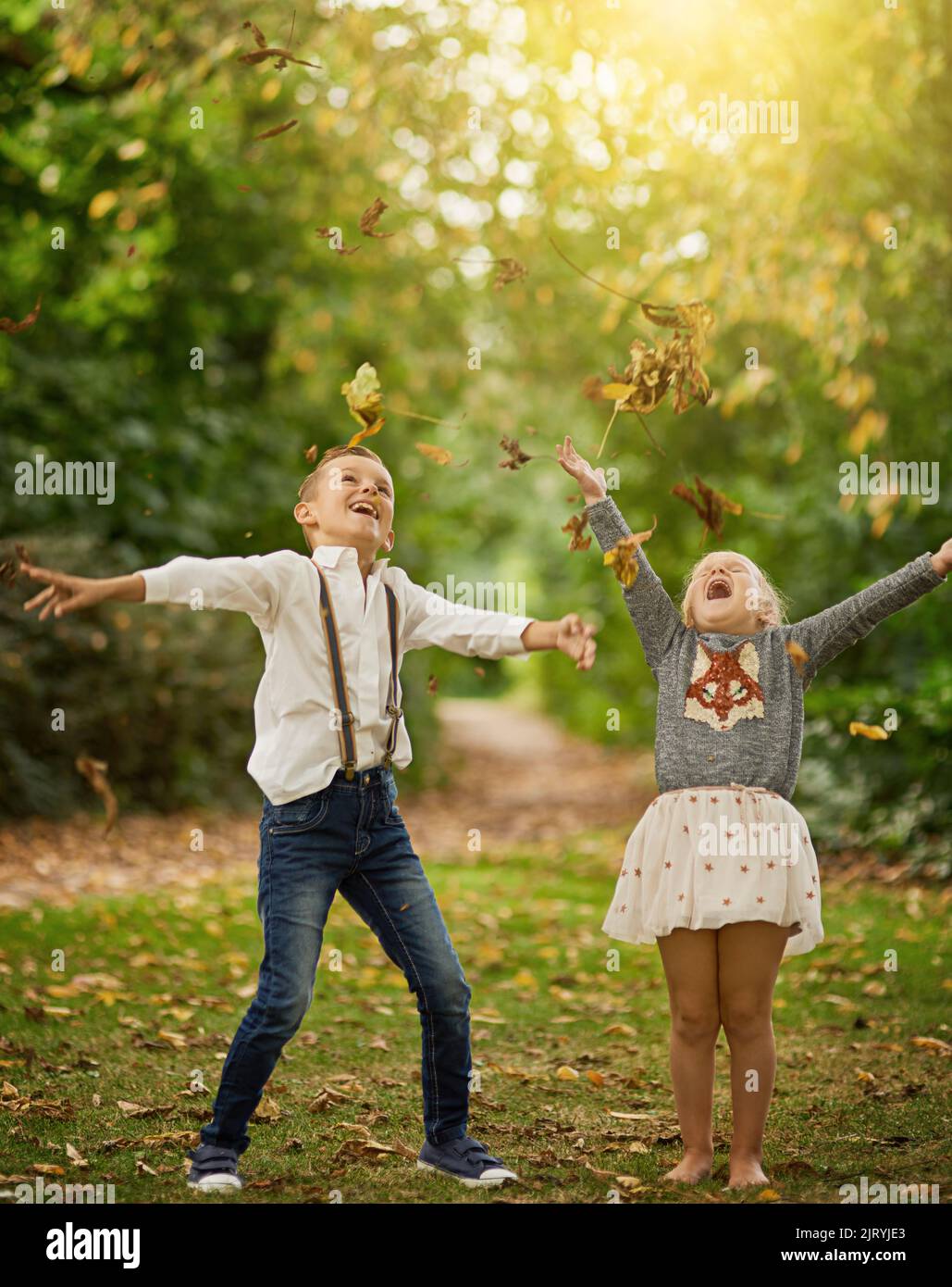Let the leaf-playing fun begin. a boy and his little sister having fun ...