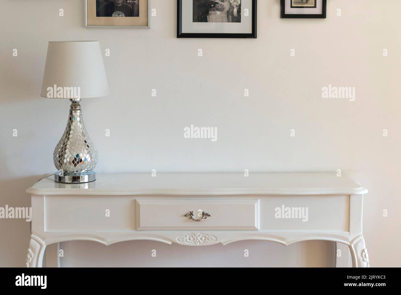 View of a white classic console with a lamp on it Stock Photo - Alamy