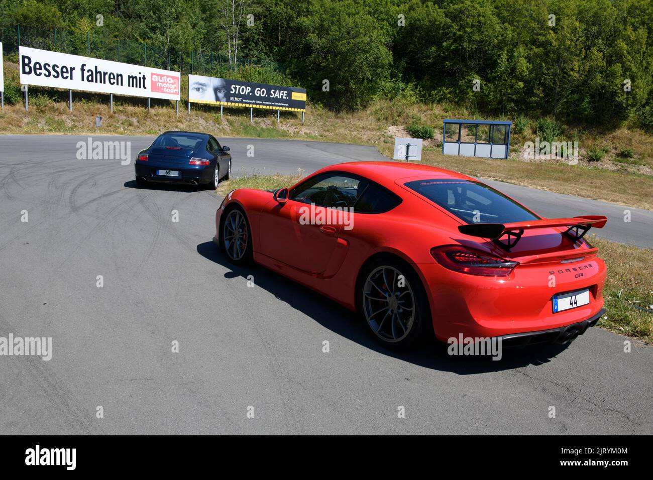 Two sports cars in front red Porsche Cayman GT4 with rear spoiler in ...