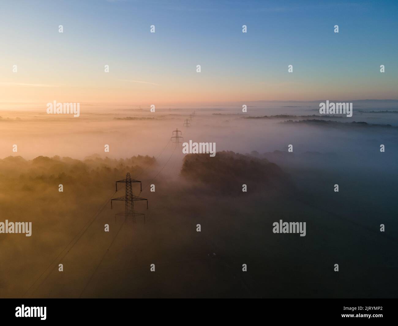 Aerial Photograph of a misty sunrise with power lines disappearing into ...