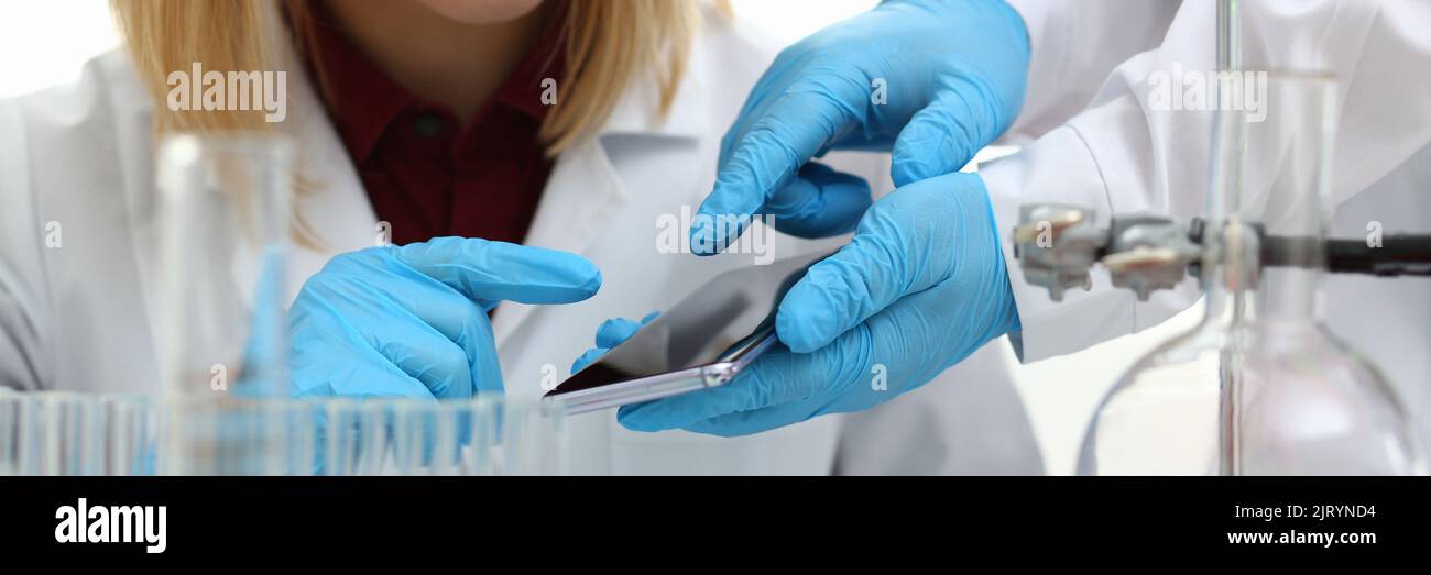 Scientist in chemical laboratory holds smartphone with a display in ...