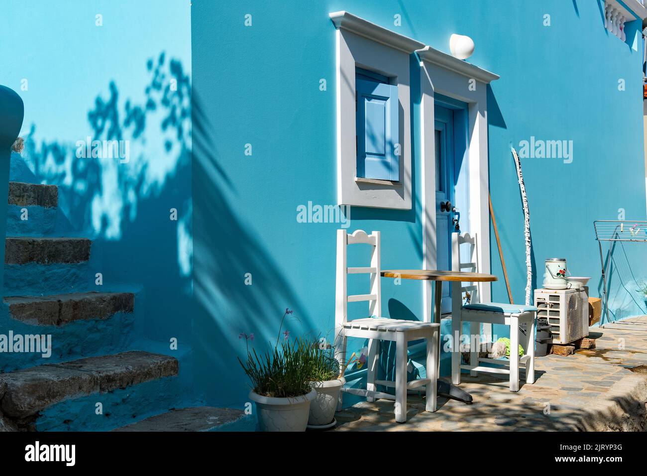 Traditional greek house with blue facade with white arched door and ...