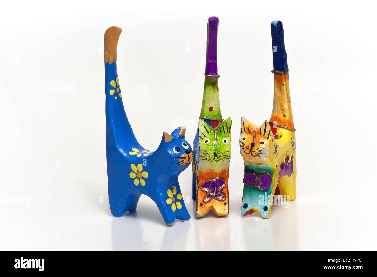 Three wooden cats figures brightly painted isolated Stock Photo - Alamy