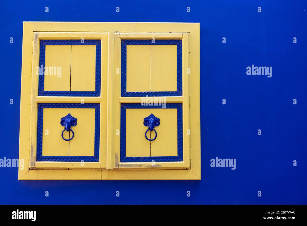 Plain colour wall with blue colour window. Selective focus with ...