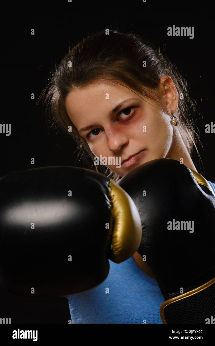 Pretty Muay Thai female boxer with bruise on face in attack pose ...