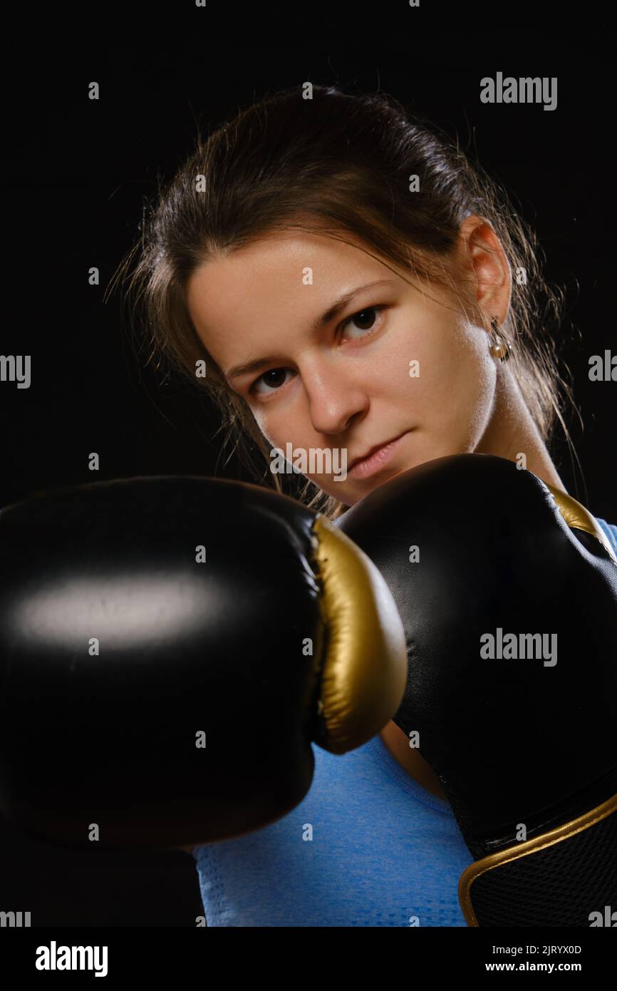 Pretty Muay Thai female boxer in attack pose. Fitness young woman ...