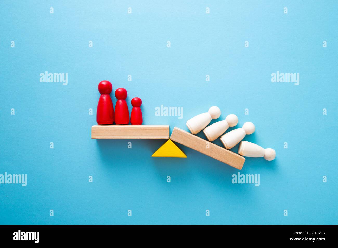 Team standing on a wooden seesaw, one side winner and one side loser ...