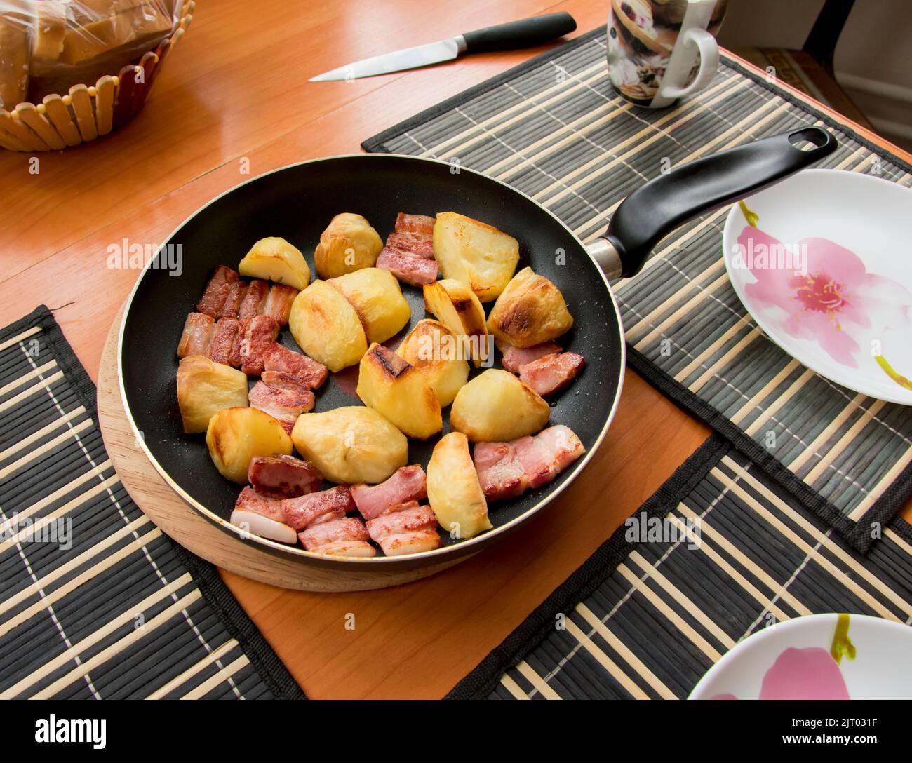 Fried pieces of baked golden potatoes and red shiny, from molten fat ...