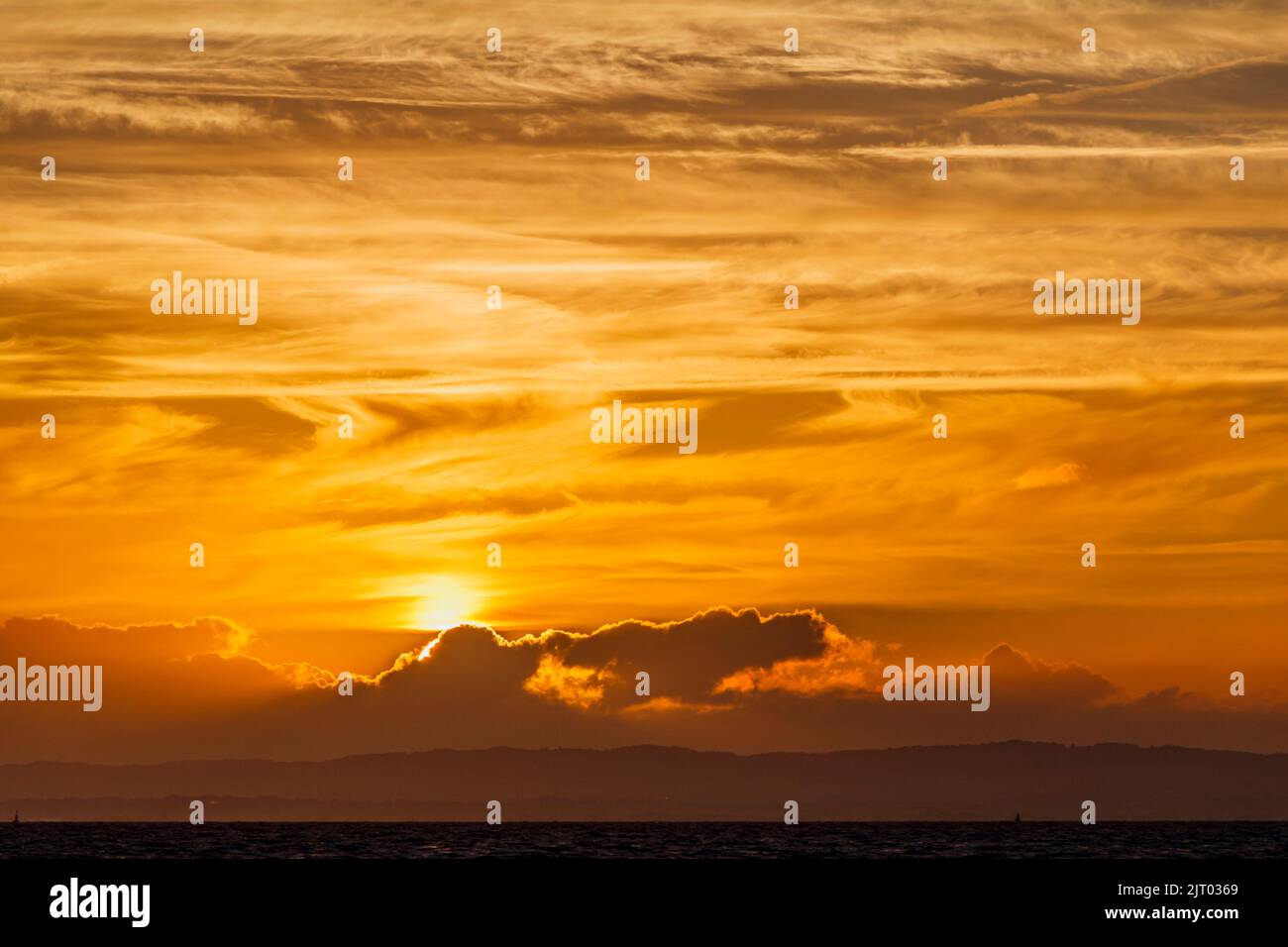 Golden glow with the setting sun lighting up the cloud cover Stock ...