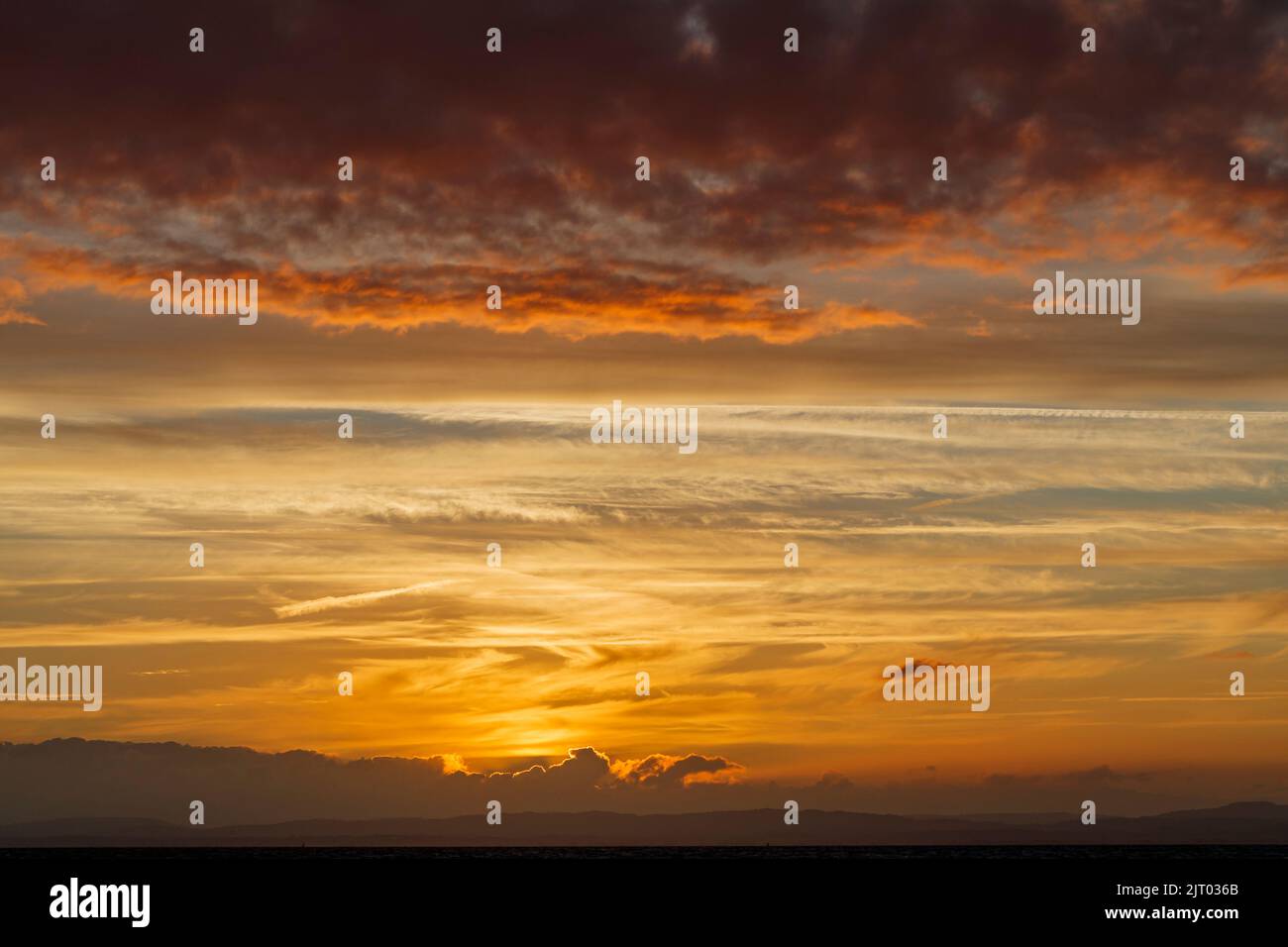 Golden glow with the setting sun lighting up the cloud cover Stock ...
