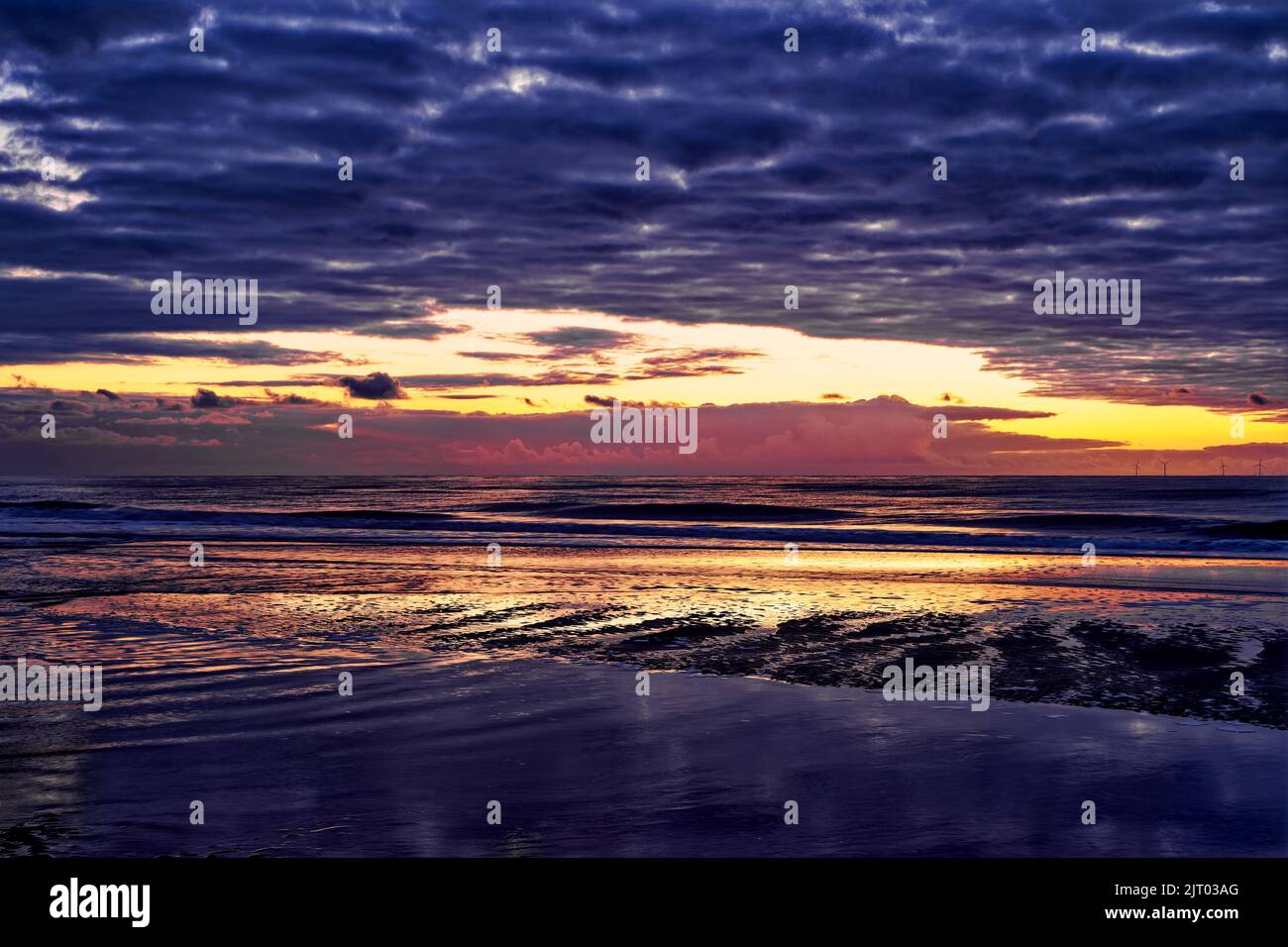 Sunset at the ocean. The dramatic sky is reflecting in the ocean ...