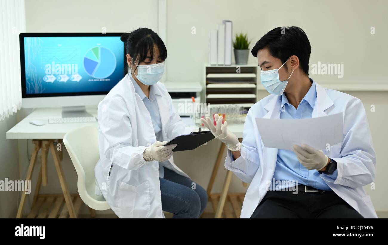 Research scientist team analyzing test samples, discussing about new ...