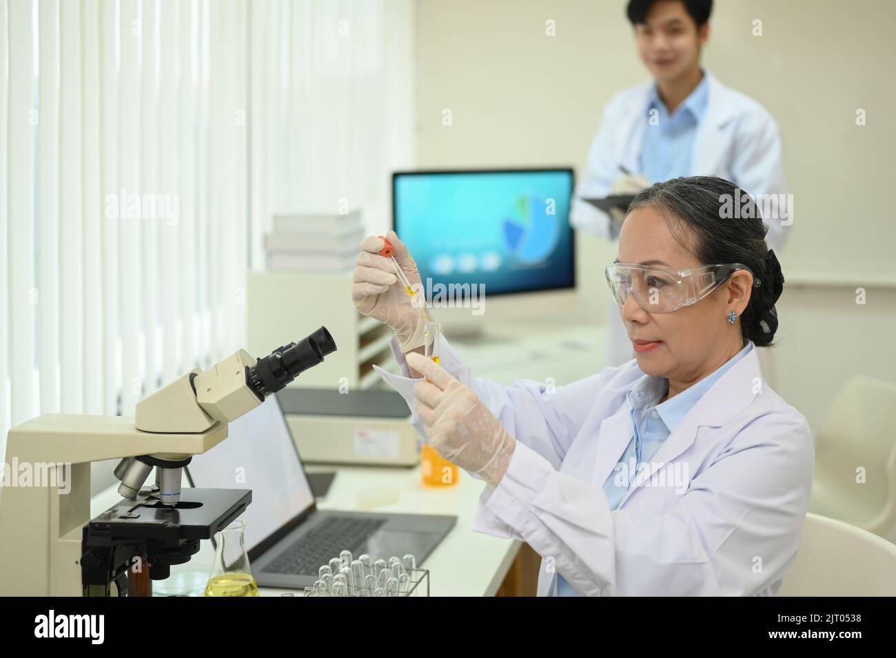 Senior female biotechnology specialist supervisor conducting experiment ...