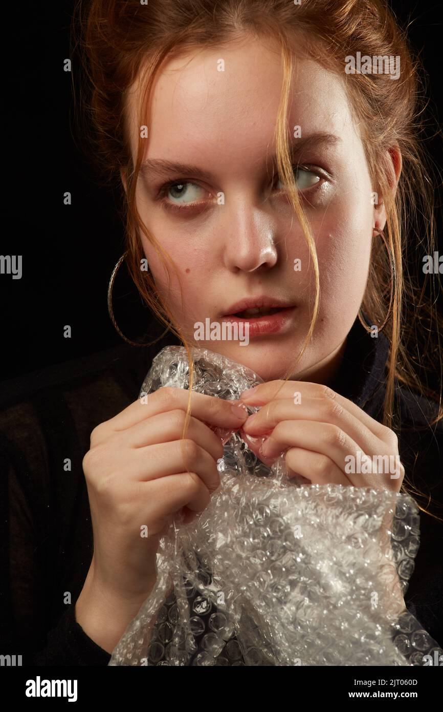 stressed woman in depression bursts bubbles of packaging cellophane ...