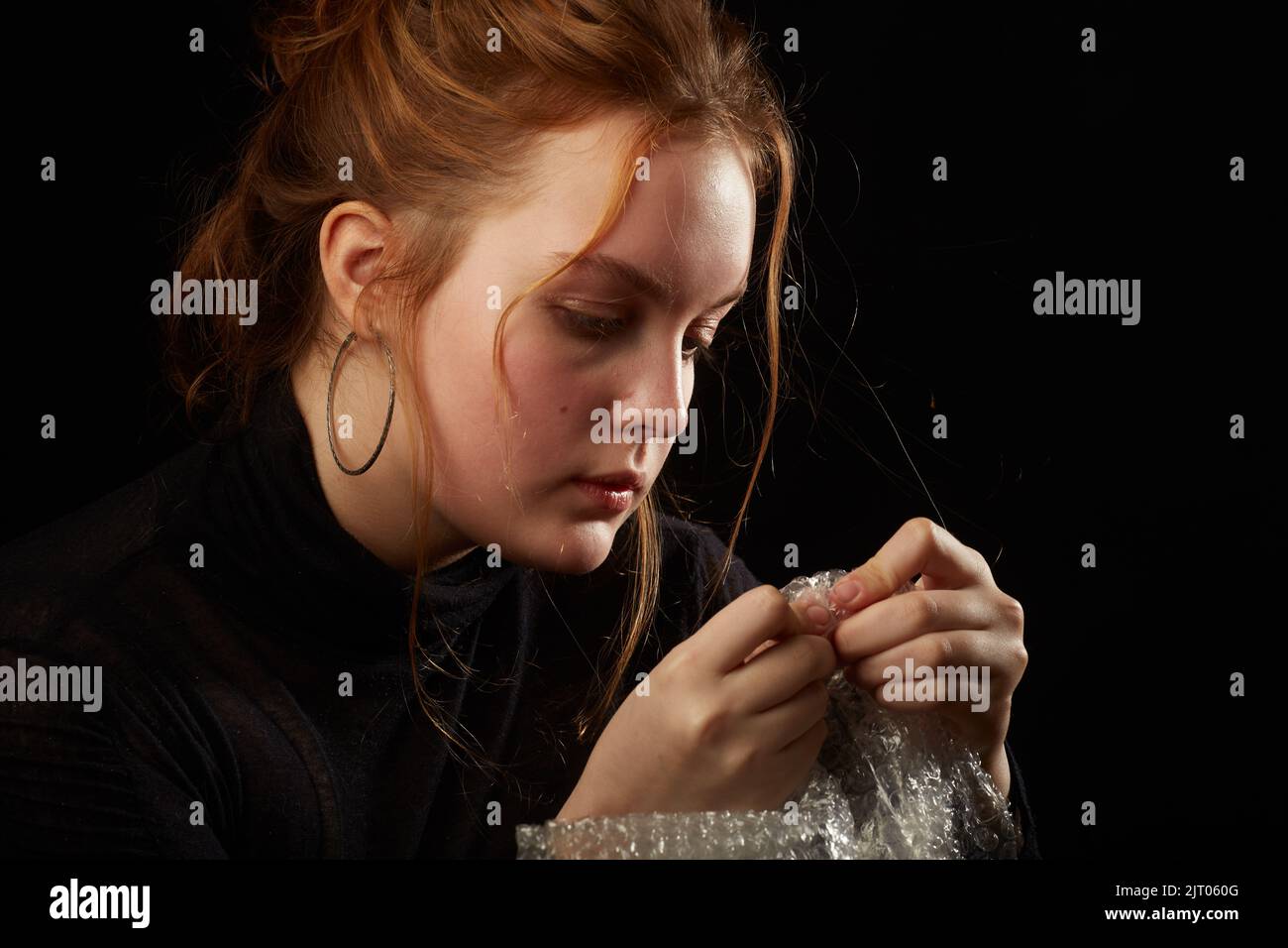 stressed woman in depression bursts bubbles of packaging cellophane ...