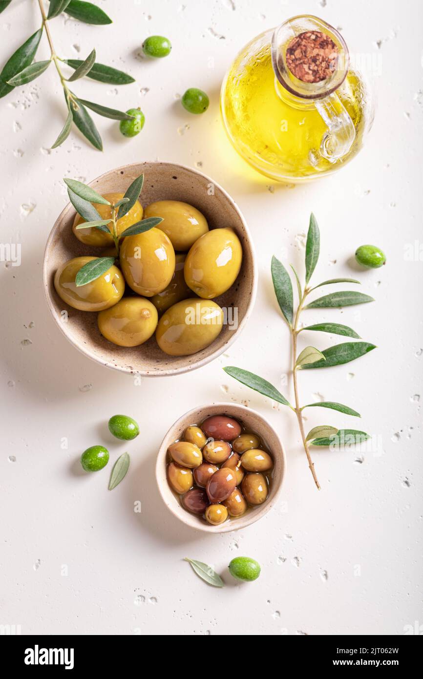 Various types of olives in bowl with an olive branch. Products made of ...
