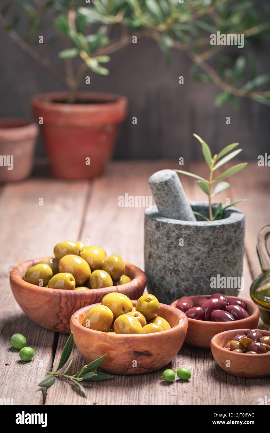 Healthy and fresh olives in bowl with an olive branch. Products made of ...