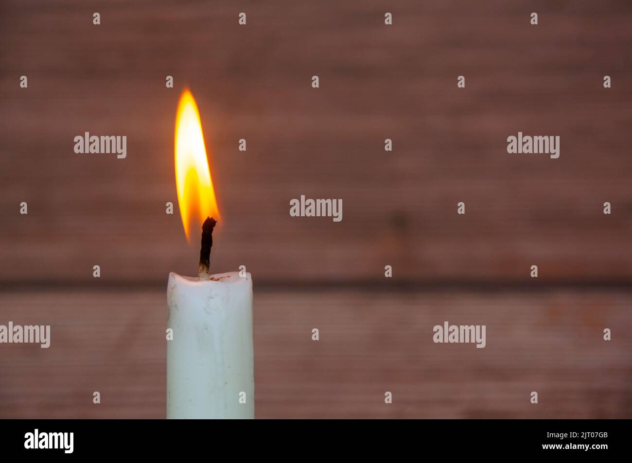 Candle light burning brightly with wooden wall background Stock Photo ...