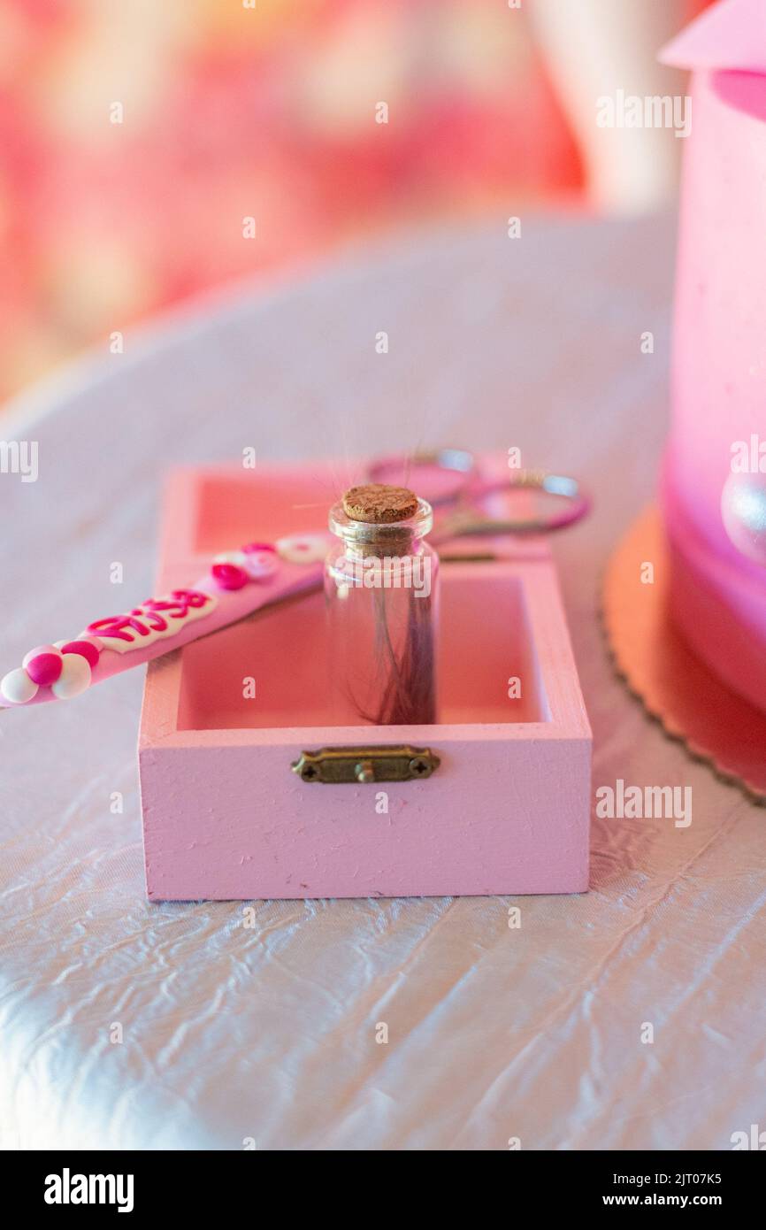The vertical view of a jar and scissors over a pink box on a white ...