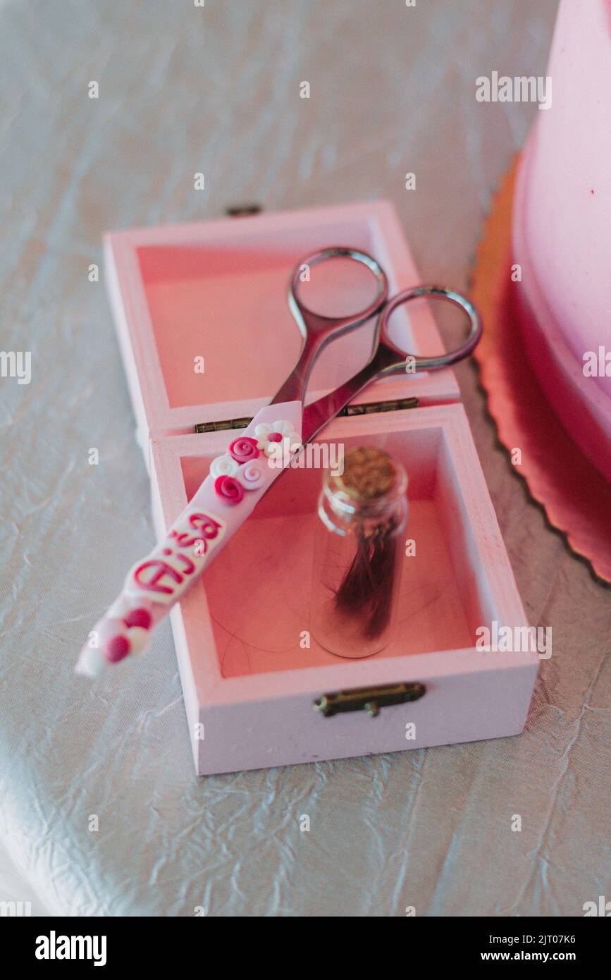 The vertical high-angle view of a jar and scissors over a pink box on a ...