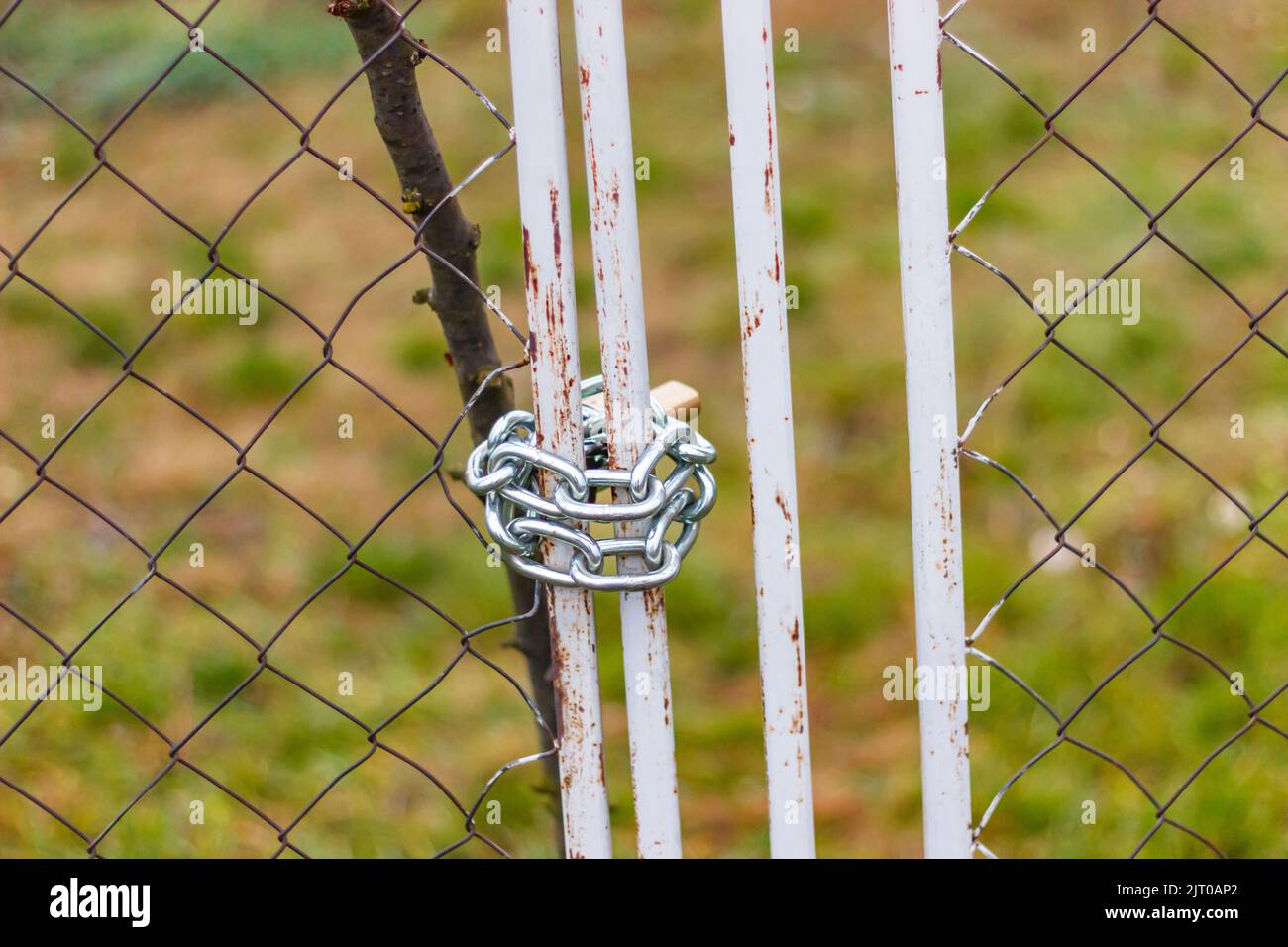 A fence locked with a silver chain Stock Photo - Alamy