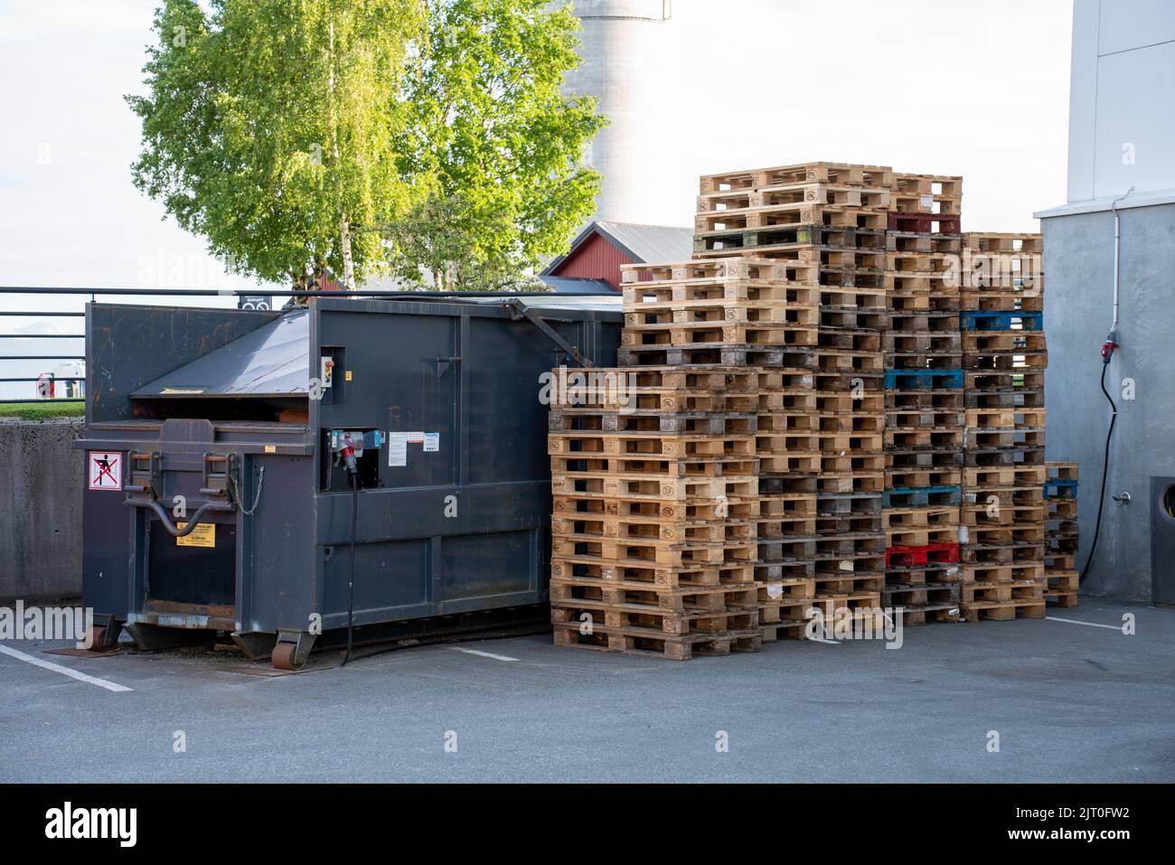 A stack of wooden pallets next to a container under the sunlight Stock ...
