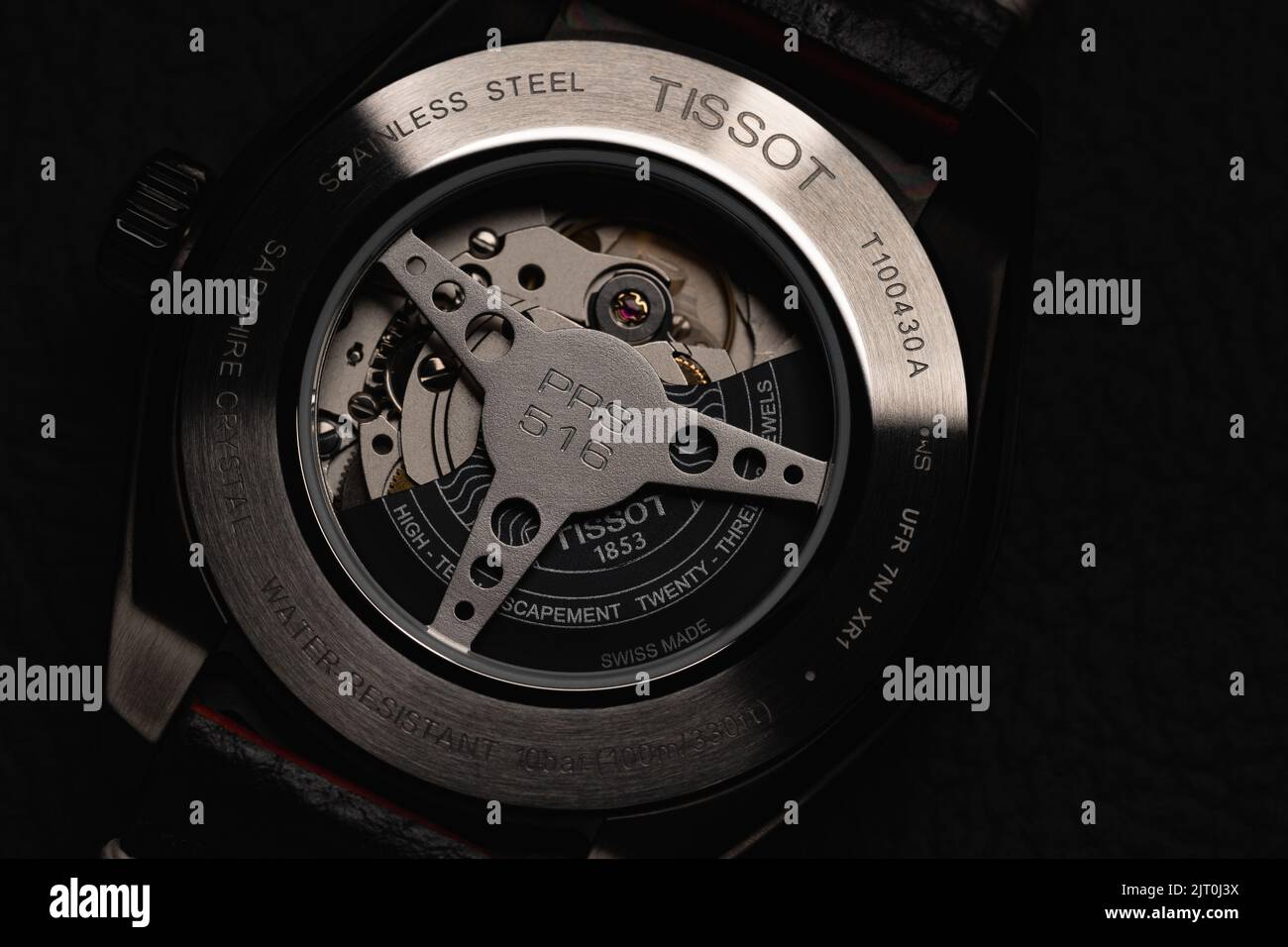 A closeup shot of details on the mechanics of a silver Tissot watch ...