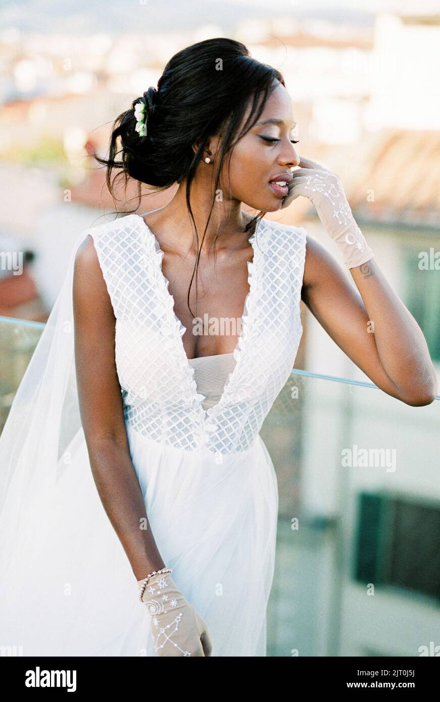 Bride stands at the glass railing on the terrace of the building Stock ...