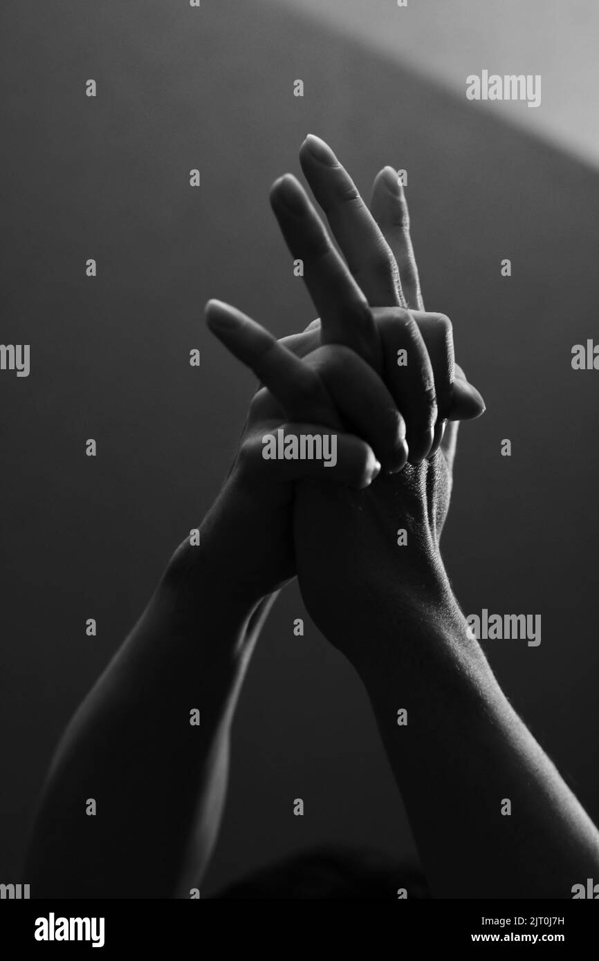A vertical grayscale shot of romantic hands holding each other Stock ...