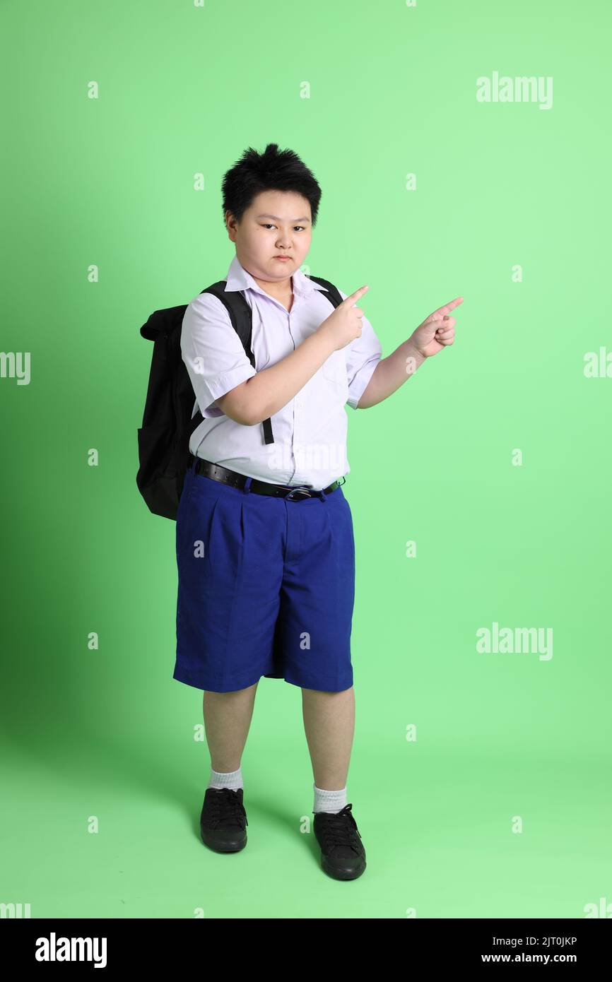 The Asian boy with student uniform on the green background Stock Photo ...