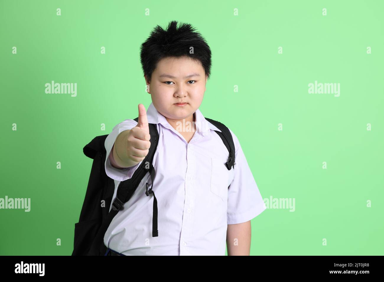 The Asian boy with student uniform on the green background Stock Photo ...