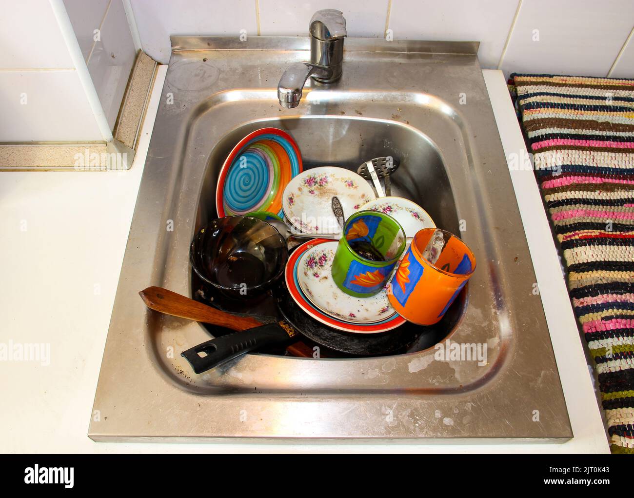 mass of dirty dishes with food scraps waiting to be washed in the metal ...
