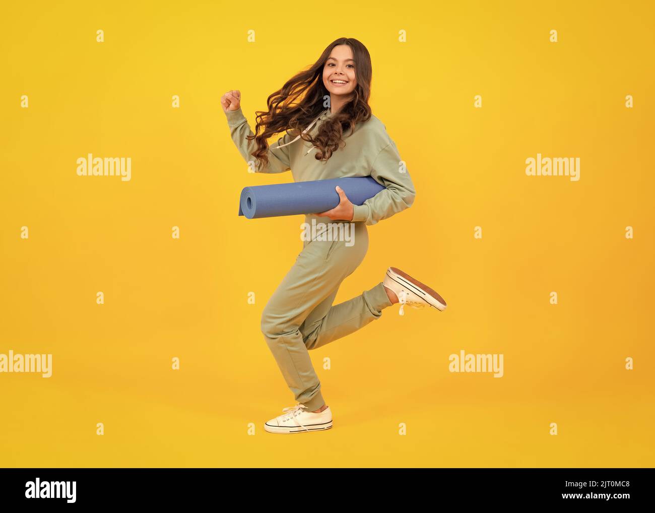 Girl teenager in tracksuit. Happy cute child in a yellow sports suit on ...
