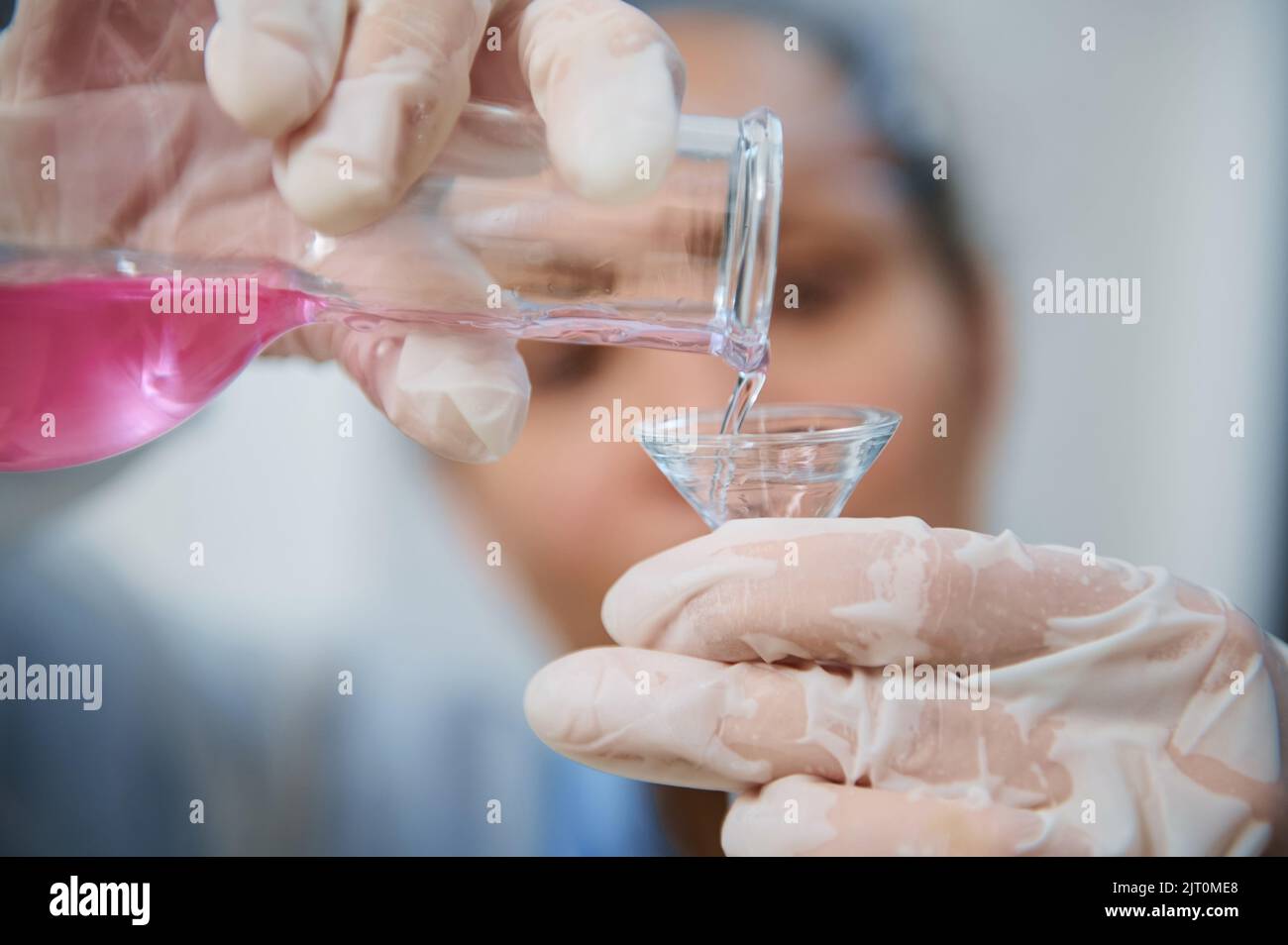 Scientist chemist pouring pink liquid hi-res stock photography and images - Alamy