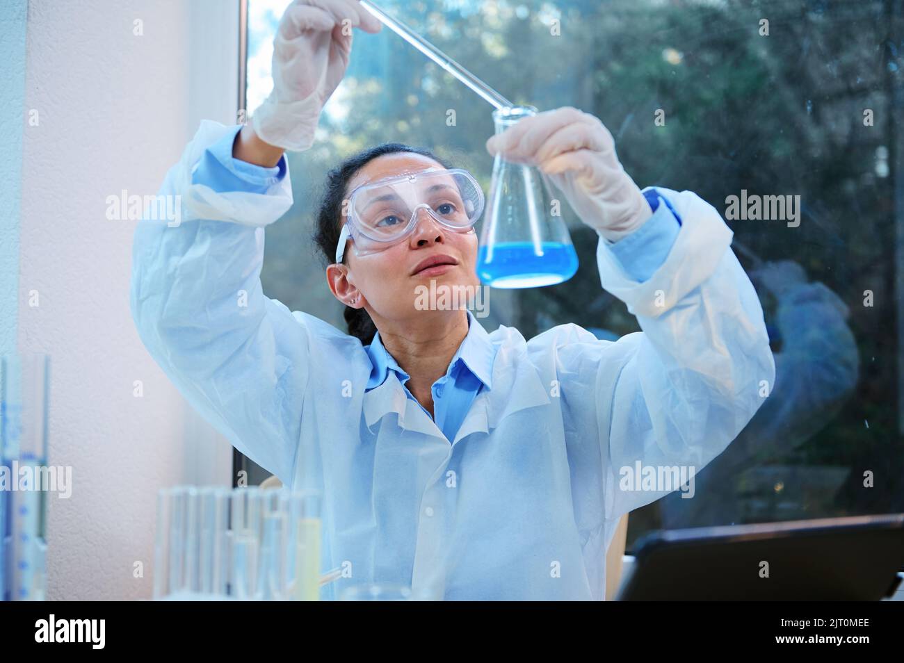 African American woman, scientist chemist dripping few reagent into a ...