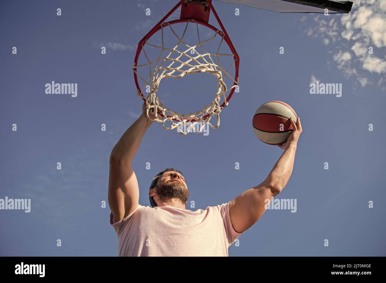 muscular man player throw basketball ball through basket, male ...