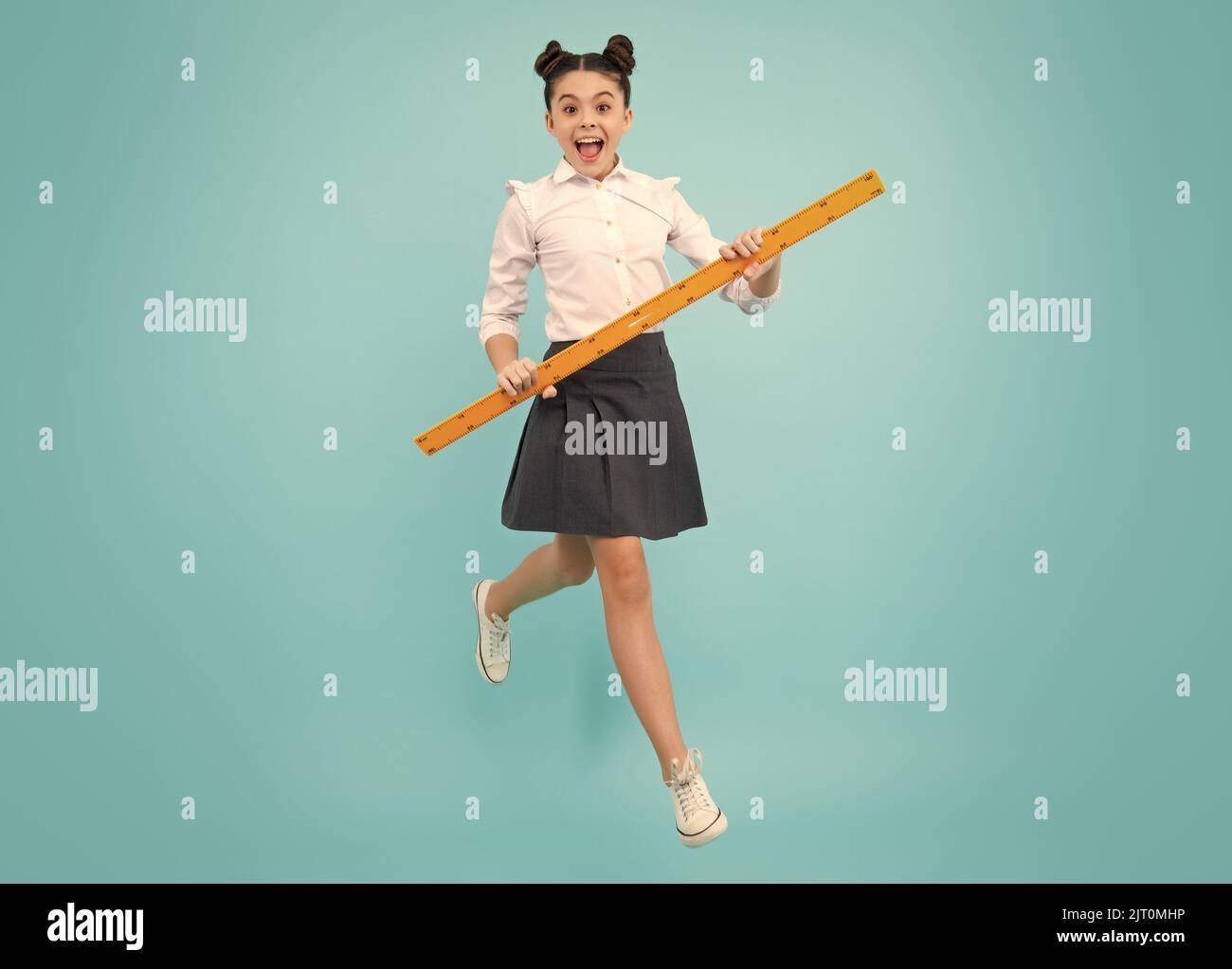 Amazed teenager. Measuring school equipment. Schoolgirl holding measure ...