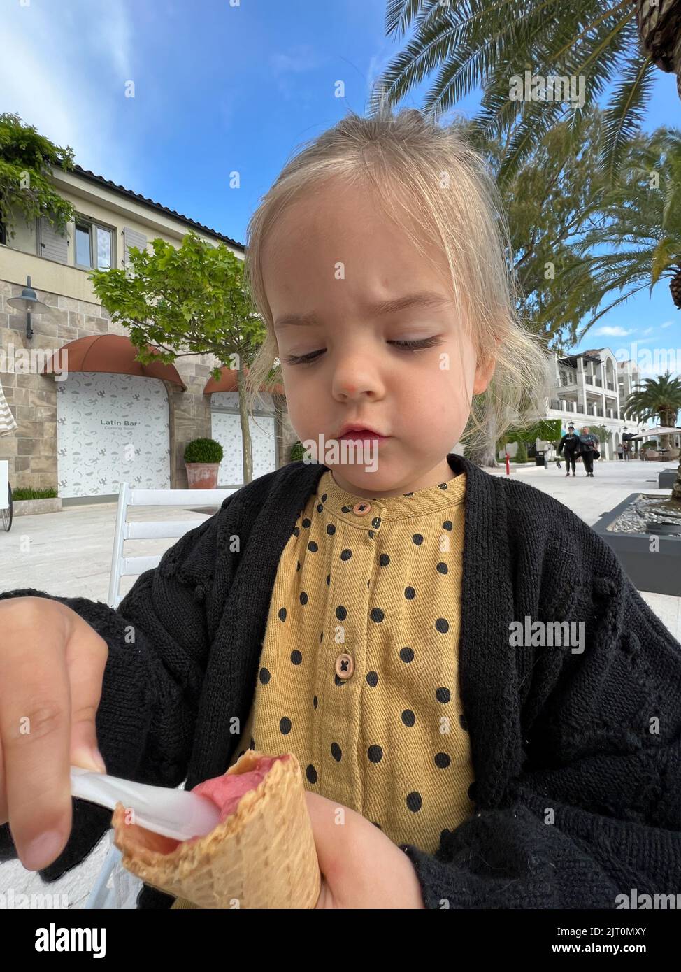 Little girl scoops up ice cream from a cone Stock Photo - Alamy