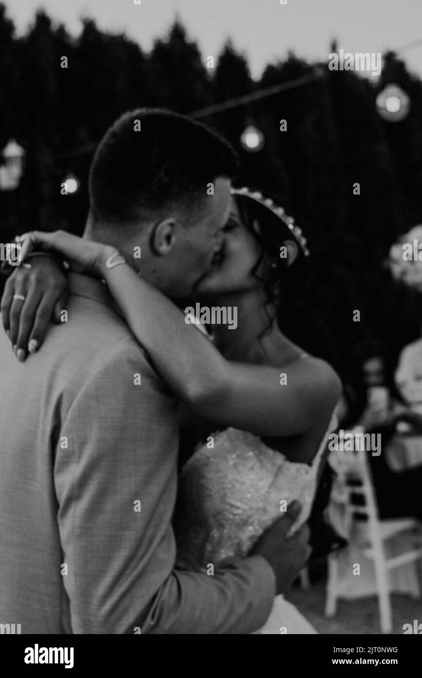 A vertical grayscale closeup of a couple kissing at their wedding Stock ...