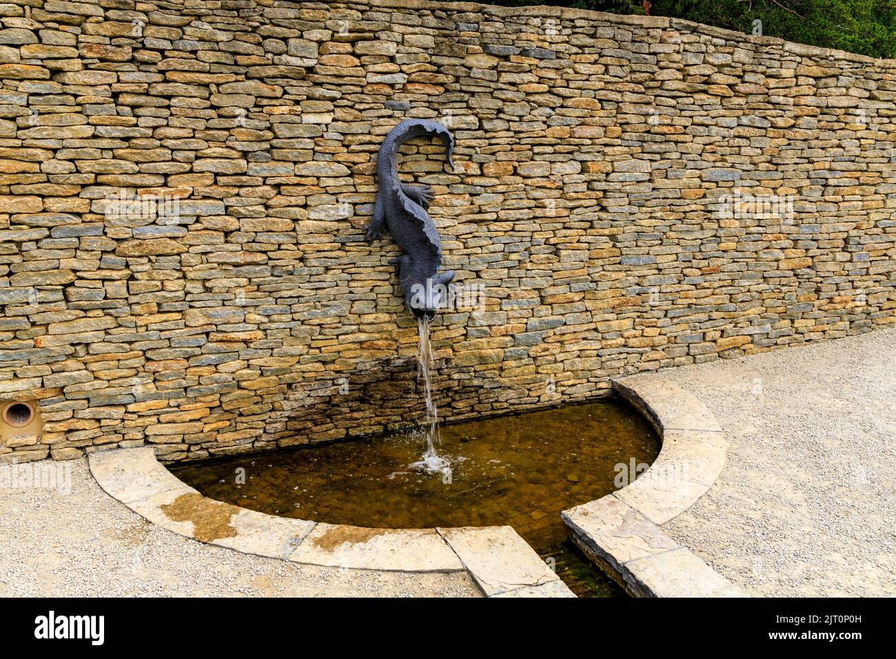 A cast metal newt water feature on a wall of Cotswold stone at 'The ...