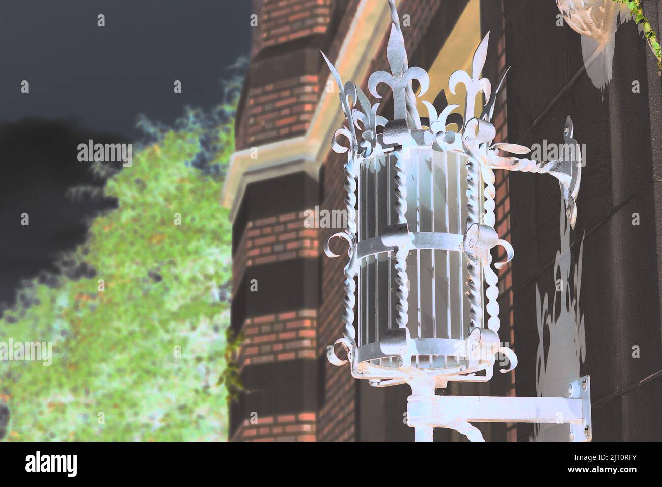 Fancy ornate street lantern hanging on a stone wall in a bright neon ...
