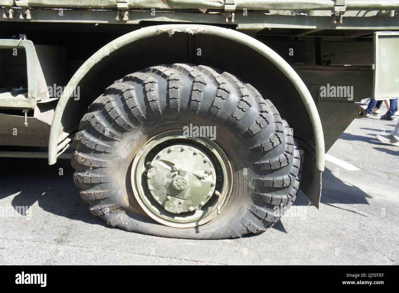 A punctured and flat tire of military equipment of the armored ...