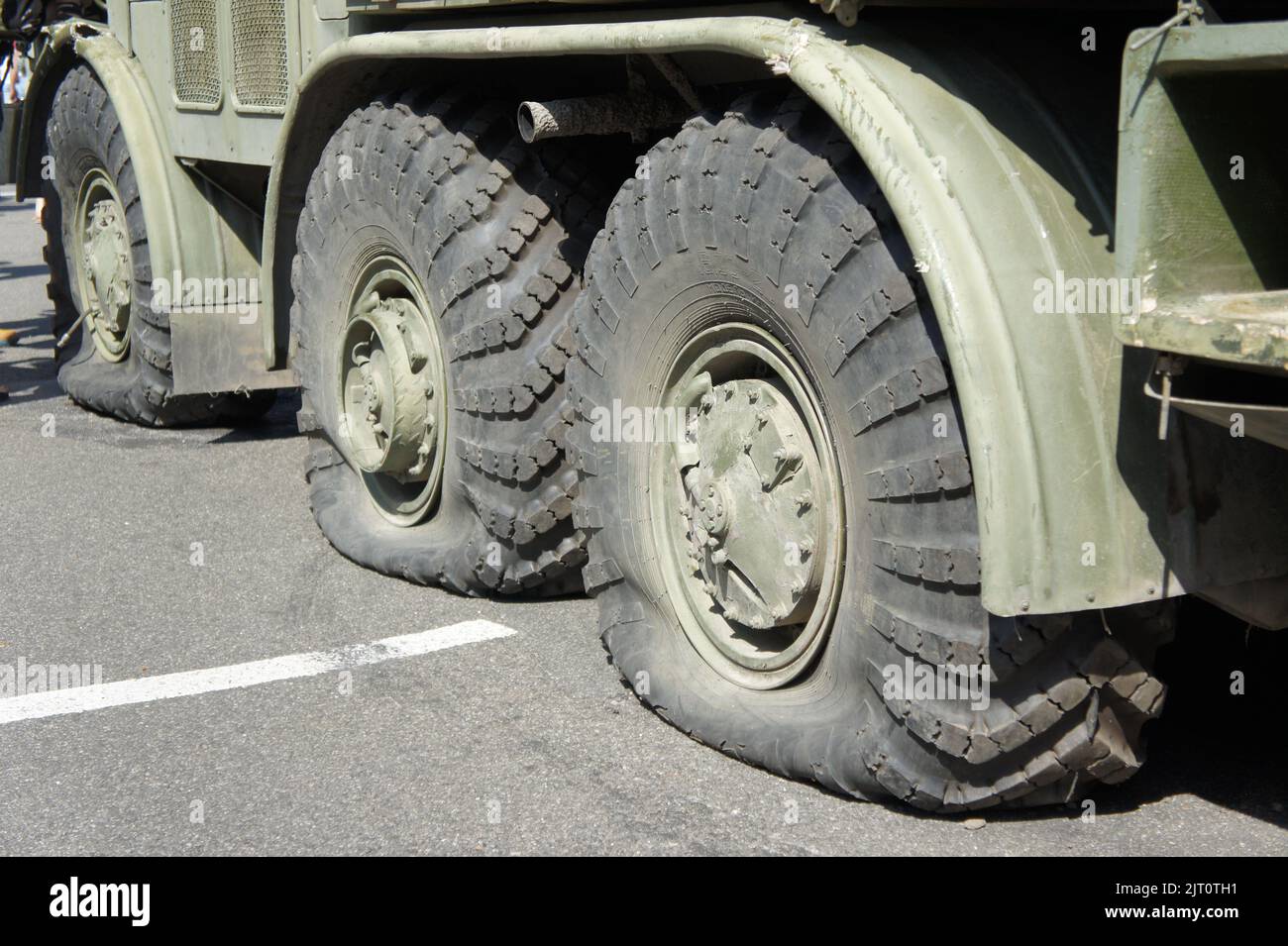 A punctured and flat tire of military equipment of the armored ...