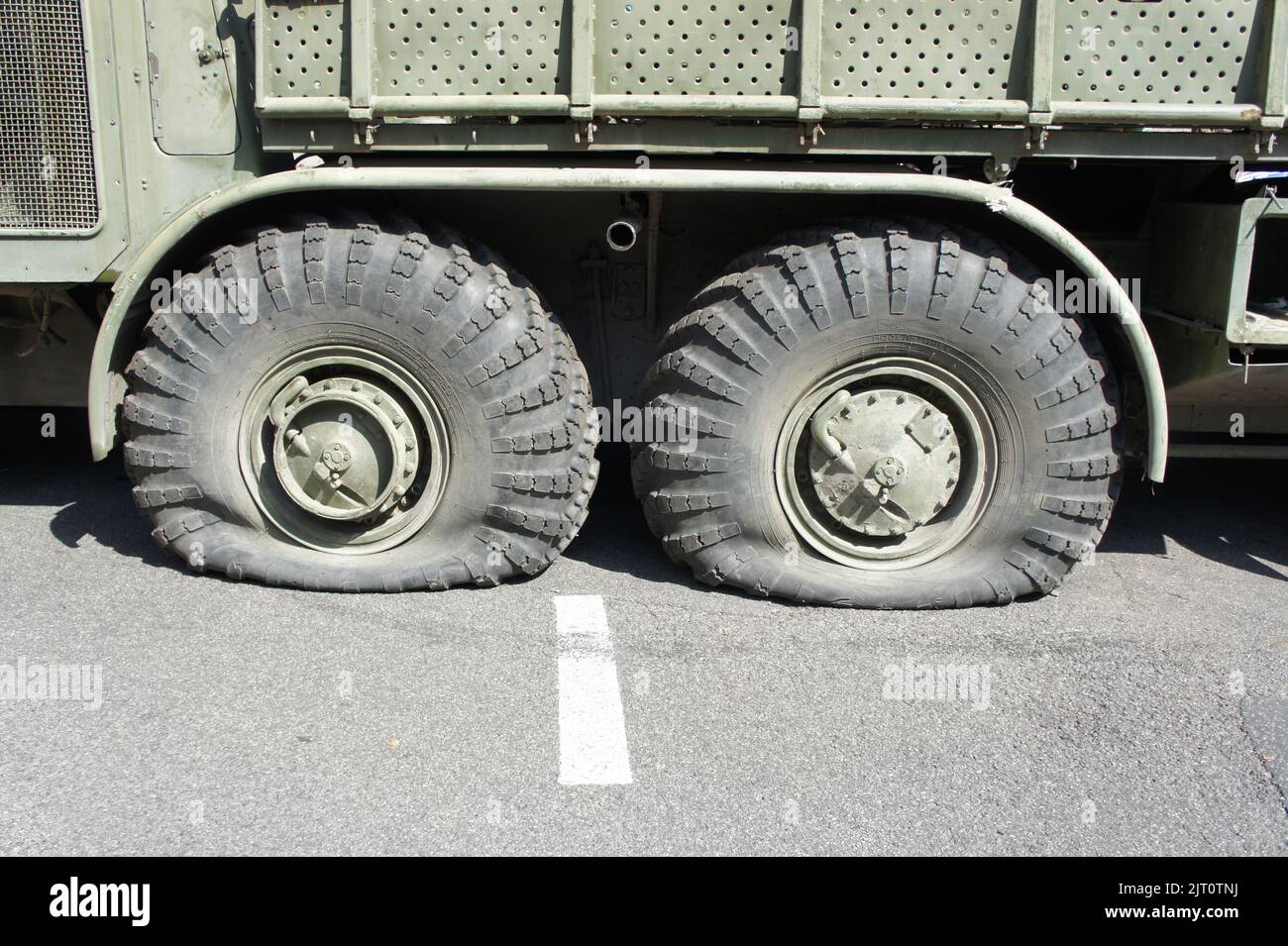 A punctured and flat tire of military equipment of the armored ...