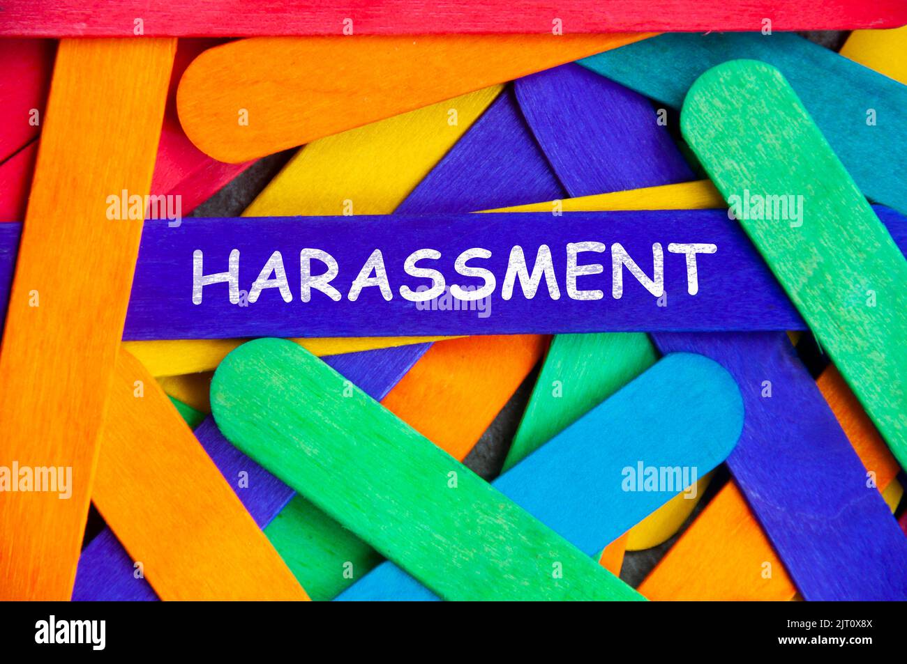 Harassment text on blue wooden stick surrounded by other sticks ...