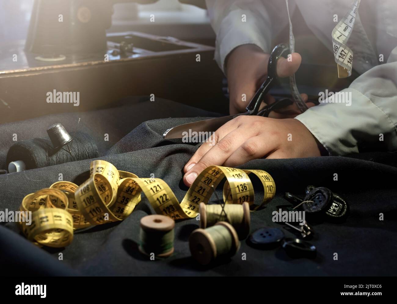 The tailor's hands sew clothes with a needle and thread. Tools for a ...