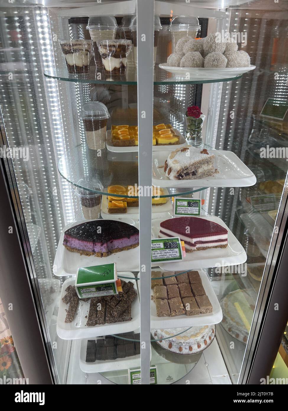 Budva, Montenegro - 01.08.22: Showcase-refrigerator with cakes, pastries, sweets and ...