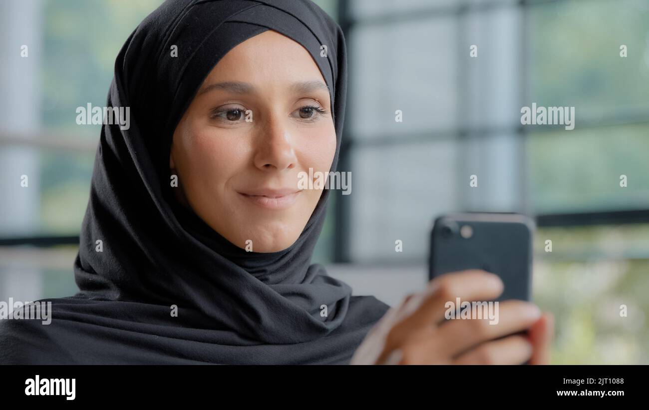 Close-up positive arab woman in hijab holding phone making order in ...